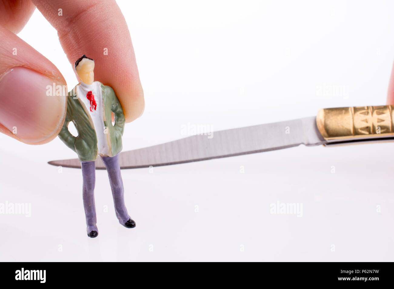 Hand holding a pocket knife near a human figure on a white background ...