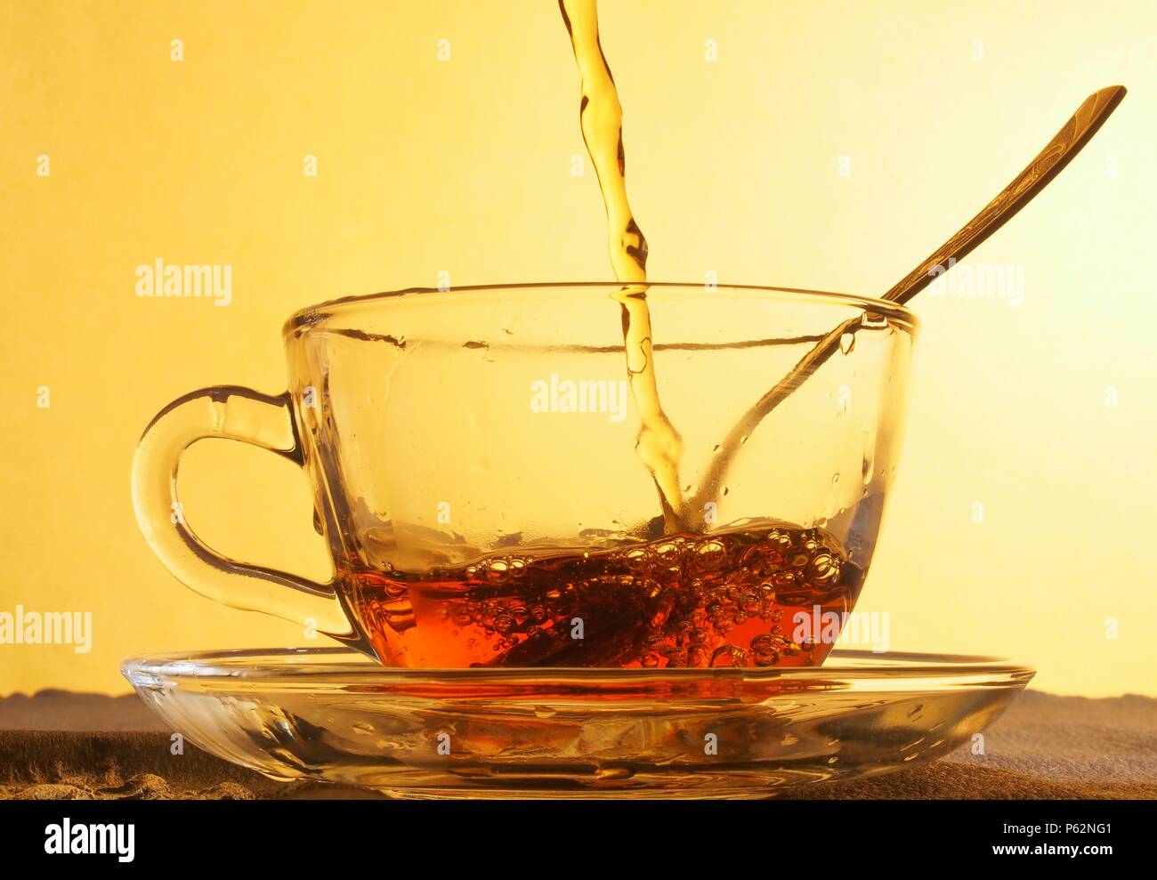 Tea is poured into a wide glass Cup. A Cup stands in a glass saucer ...