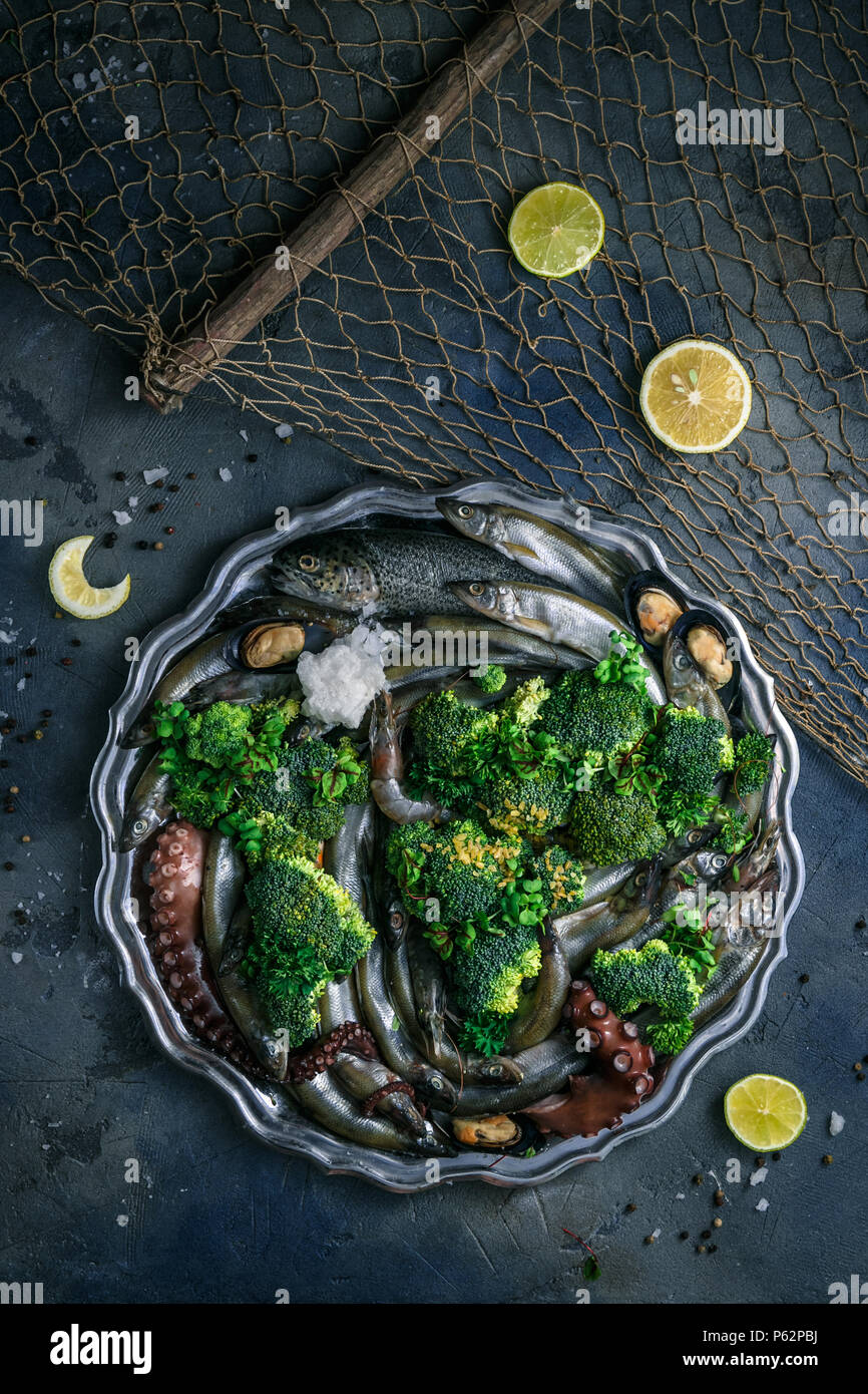 Raw Mixed seafood on a silver plate, dark background, copyspace Stock ...