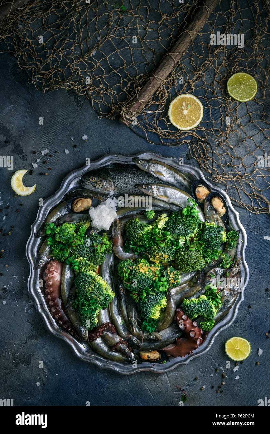 Raw Mixed seafood on a silver plate, dark background, copyspace Stock ...