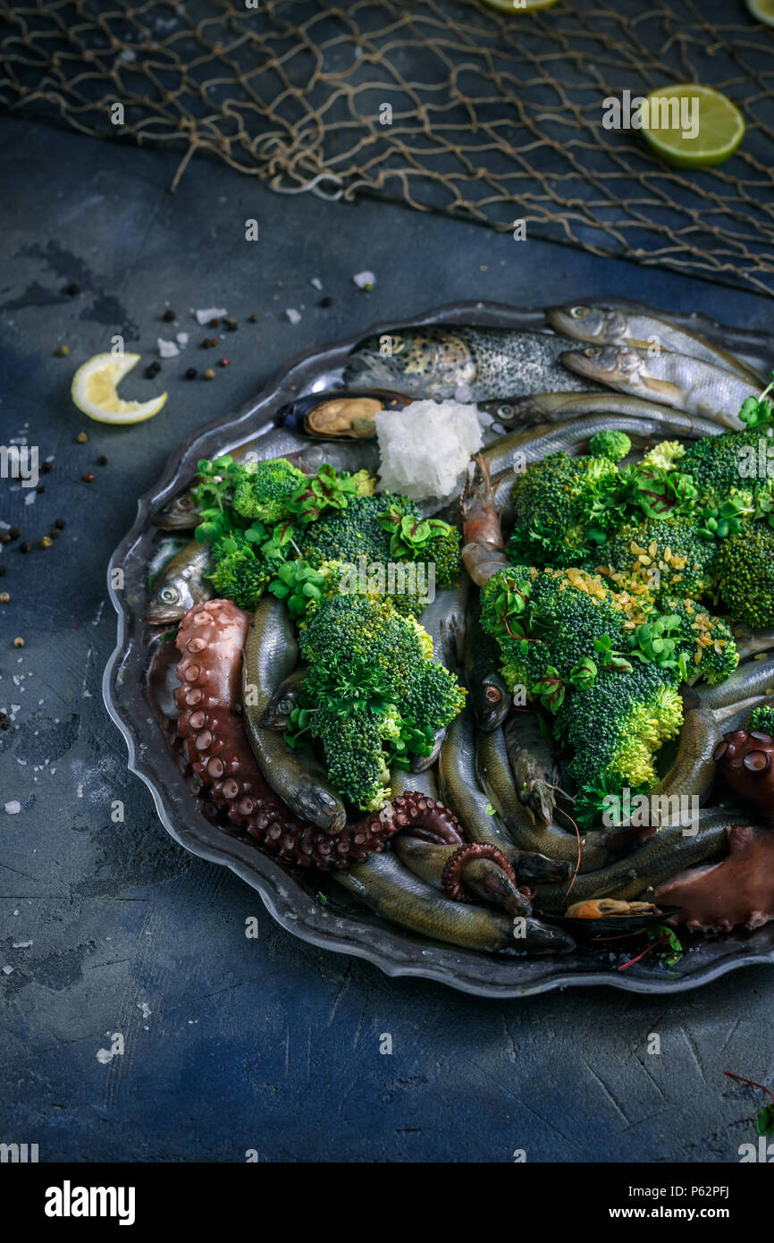 Raw Mixed seafood on a silver plate, dark background Stock Photo - Alamy