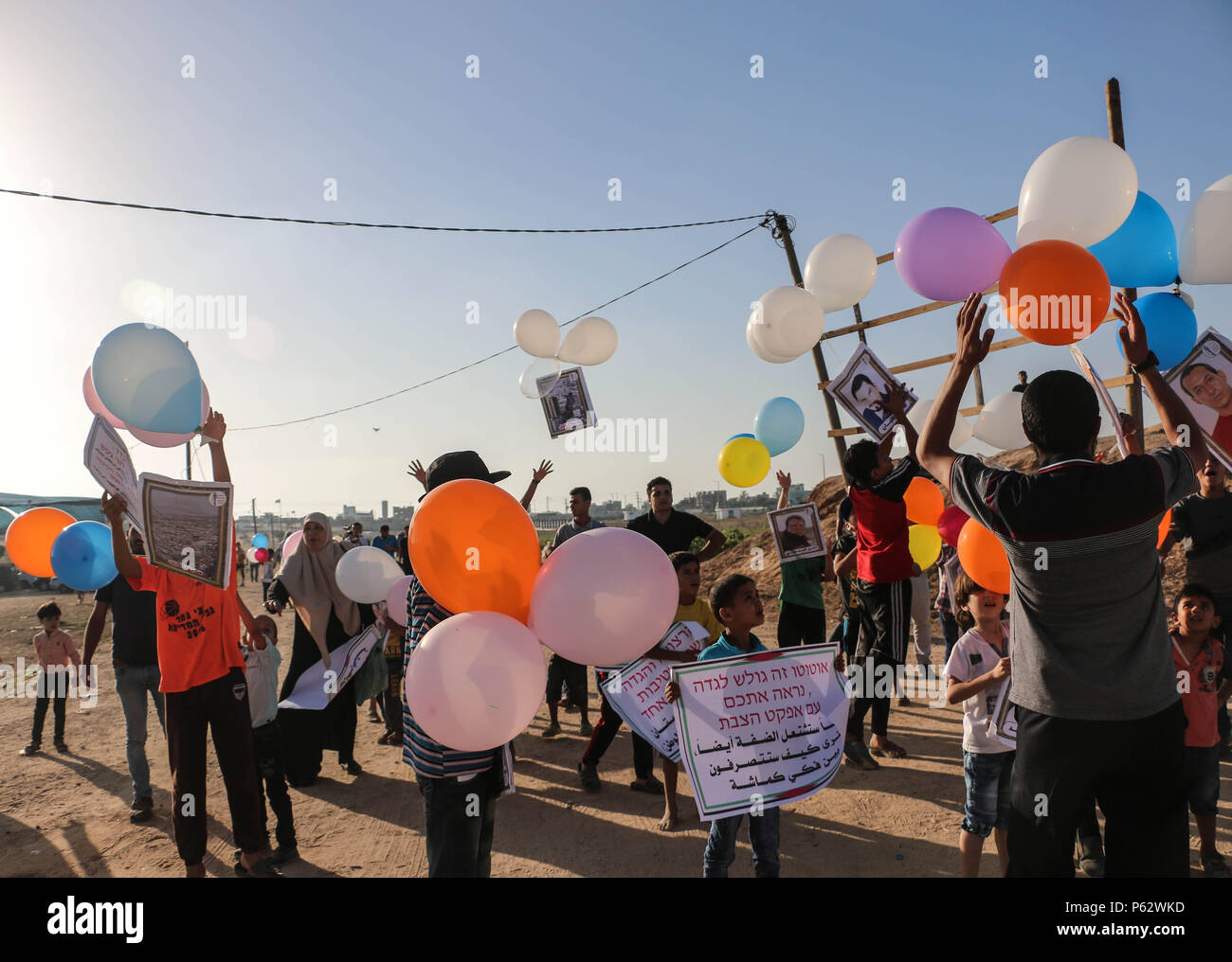 Palestinian children carry balloons carrying portraits of martyrs ...