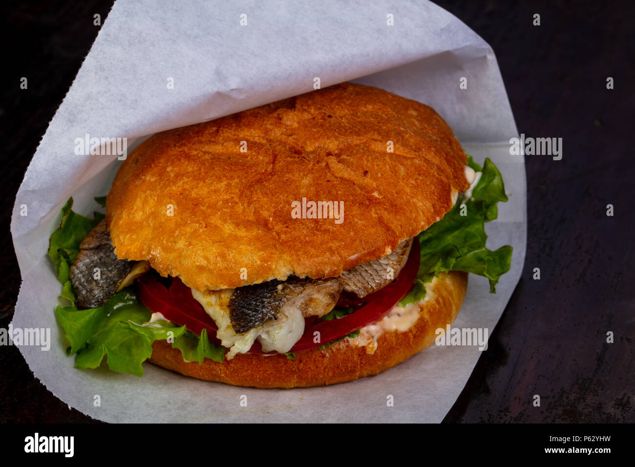 Fish burger with seabass and tomato Stock Photo - Alamy