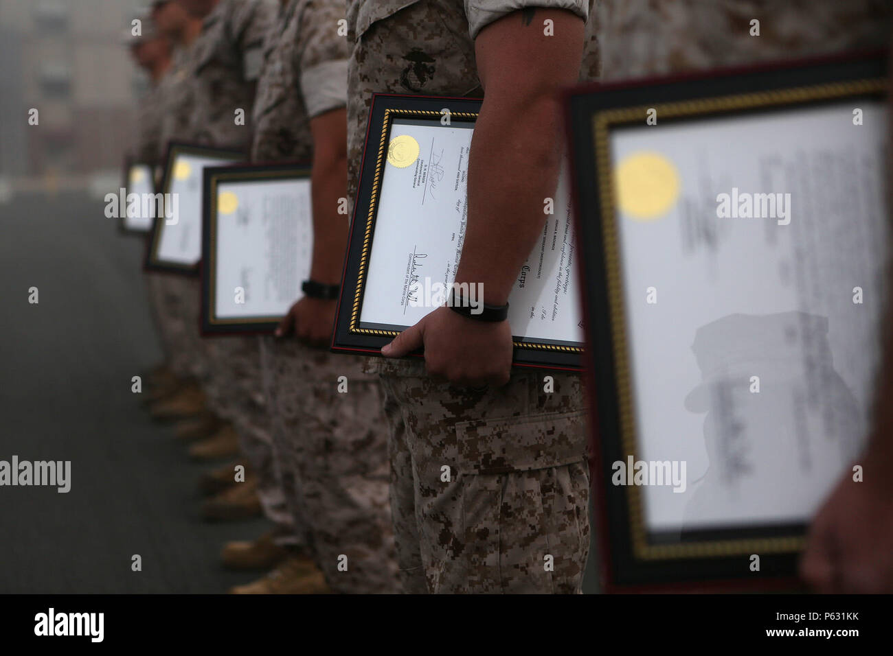 Marines hold their promotion warrants during a meritorious promotion ...