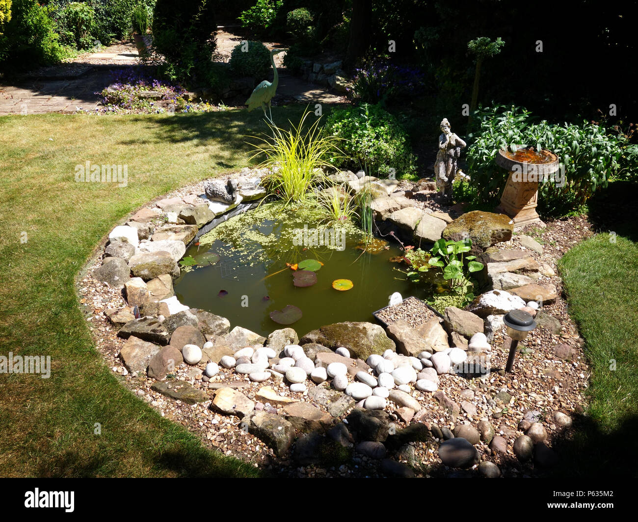 wonderful english summer garden scene showing fish pond Stock Photo - Alamy