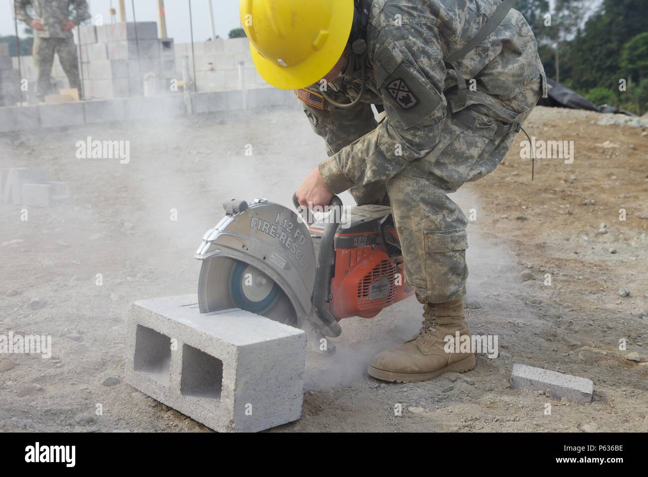 U.S. Army Sgt. Dean Poyner uses a buzzsaw to create incisions in a ...