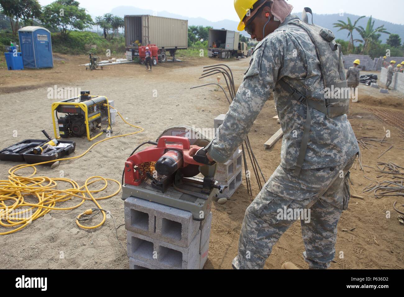 U.S. Army Sgt. Delton Edwards uses a Buzzsaw to cut bars to help build ...