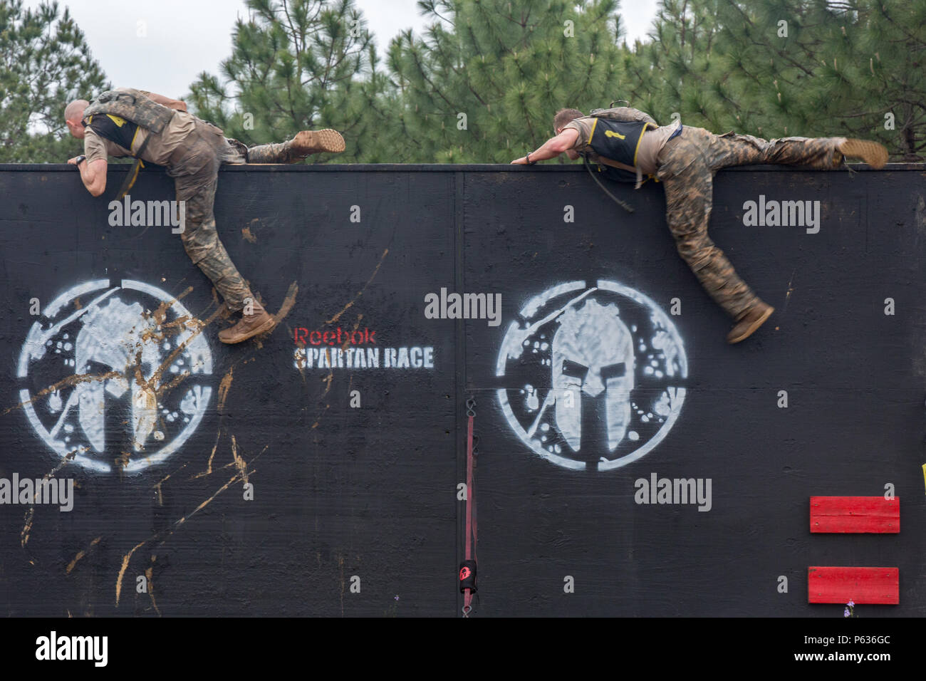 U.S. Army Soldiers climb over an 8-foot wall, as part of today's ...