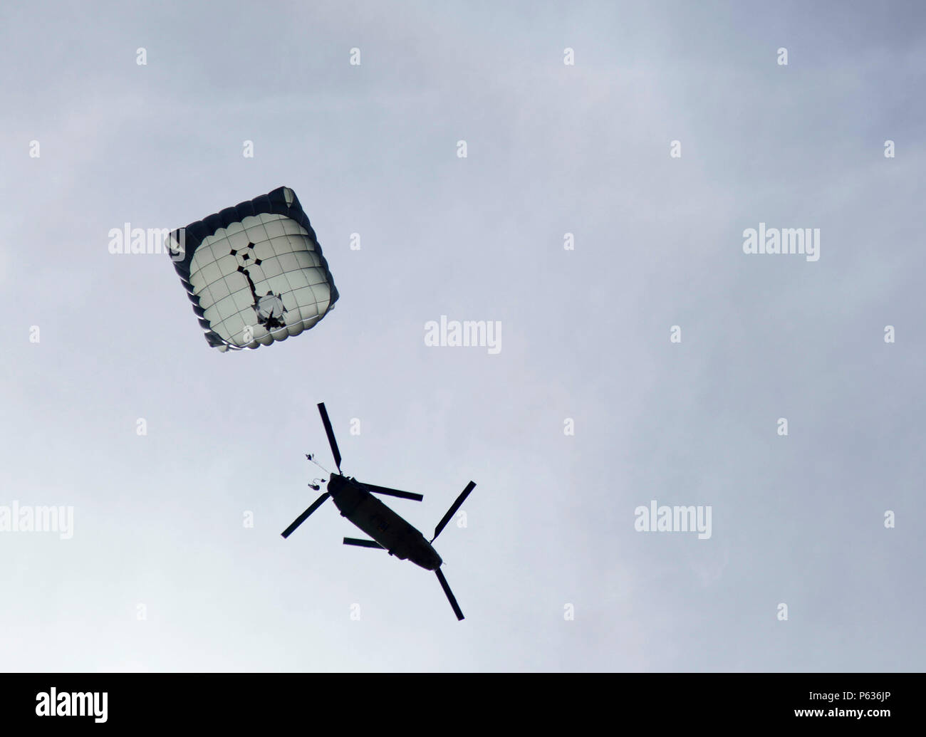 A paratrooper from Fort Bragg, N.C., performs a static line jump from a ...