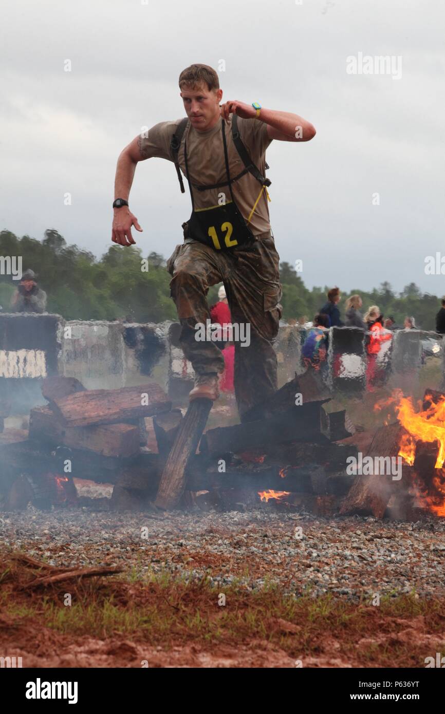 A U.S. Army Ranger jumps burning logs at the Spartan Race during the ...