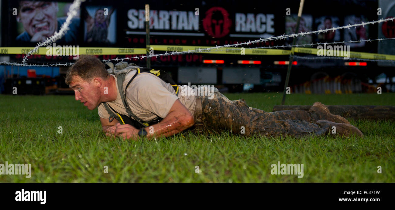 A member of the United States Army tackles a low wire entanglement ...