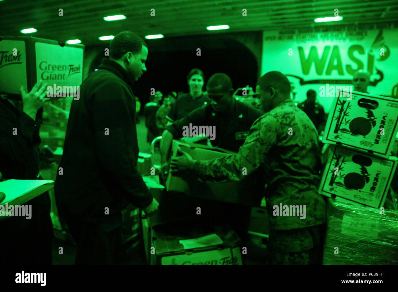 U.S. Marines and Sailors help each move supplies onto the USS WASP ...