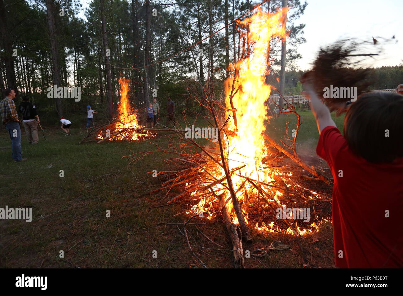 Fathers watch as their sons build competing fires in an attempt to burn ...