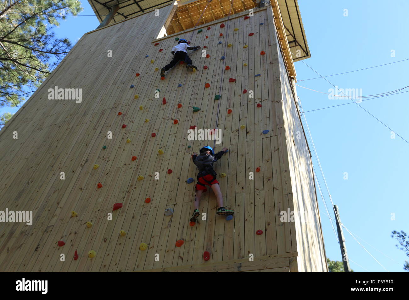 Fathers watch as their sons climb ever higher at the climbing wall ...