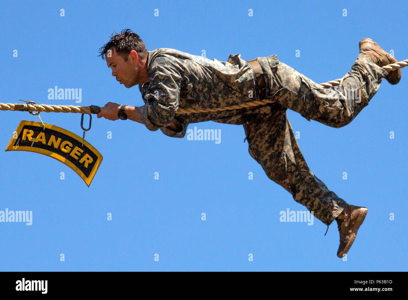 U.S. Army Ranger moves across a rope to touch the U.S. Army Ranger tab ...