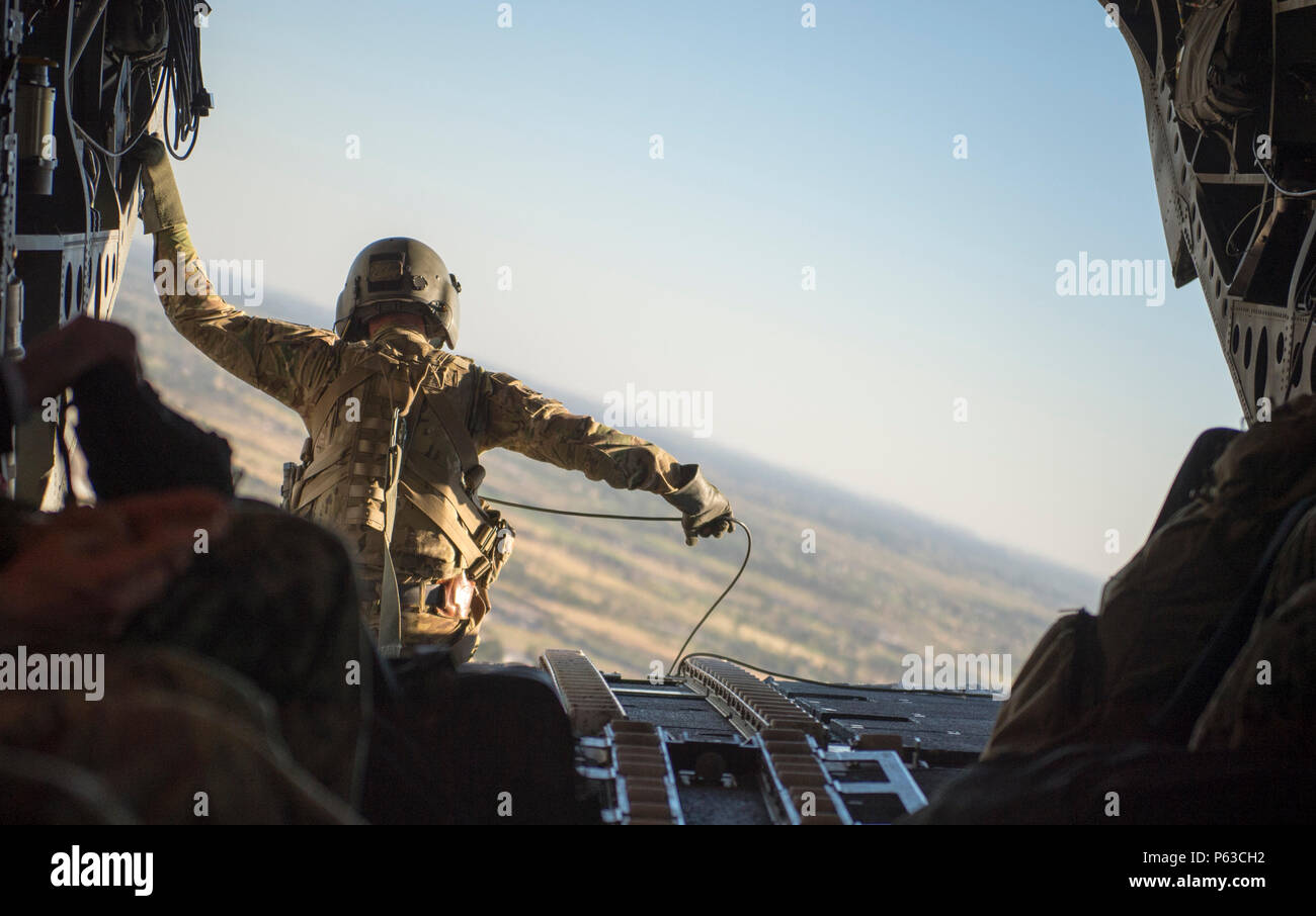 A U.S. Army aircrewman sits at the edge of a CH-47 Chinook helicopter ...