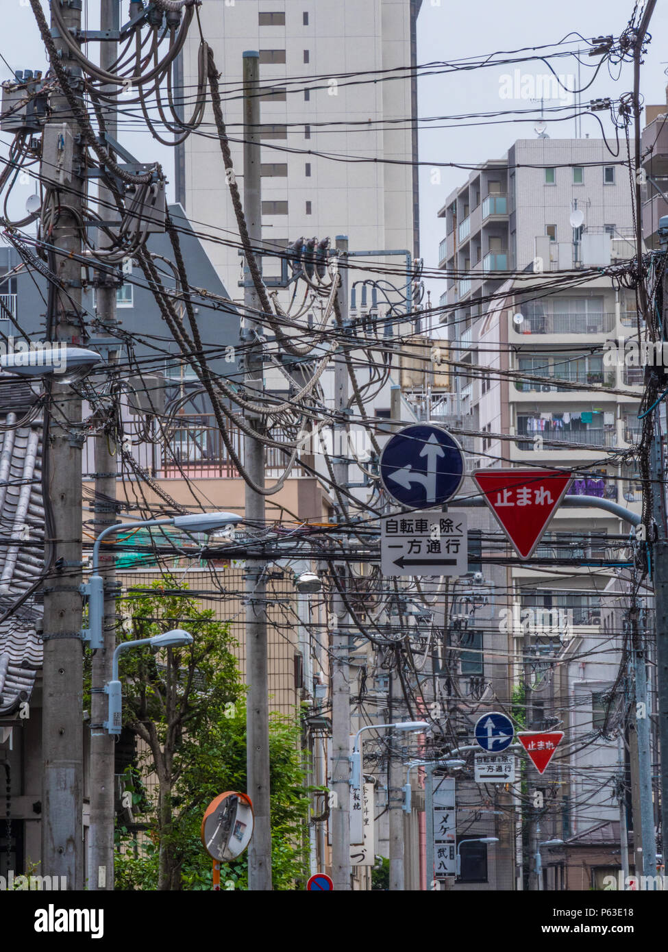 Street view in Tokyo full with electricity cables and connections ...