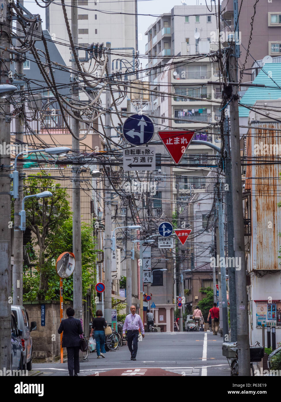 Street view in Tokyo full with electricity cables and connections ...