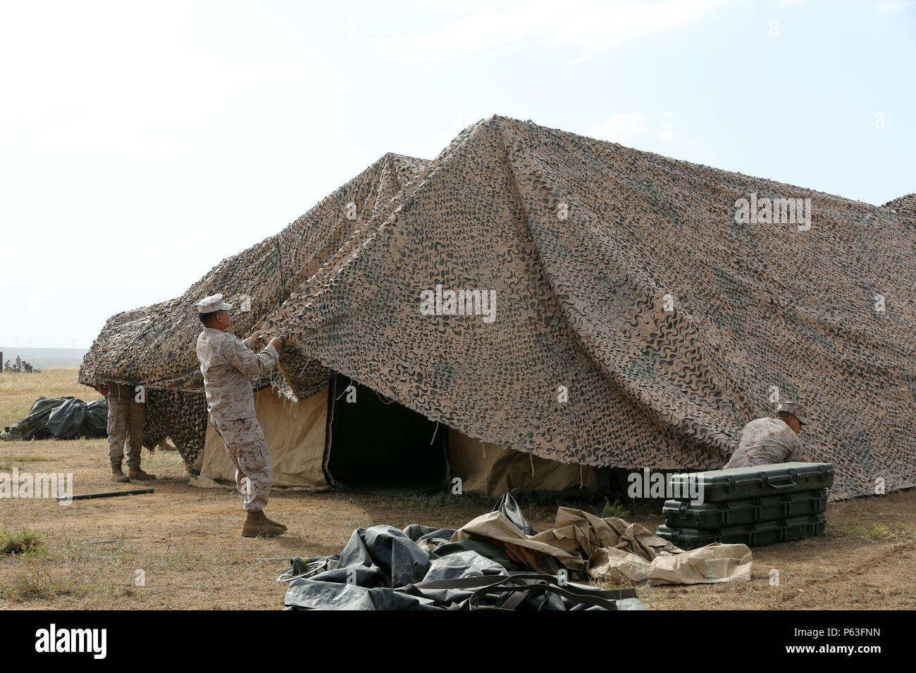 Marines with the 11th Marine Expeditionary Unit lay camouflage netting ...