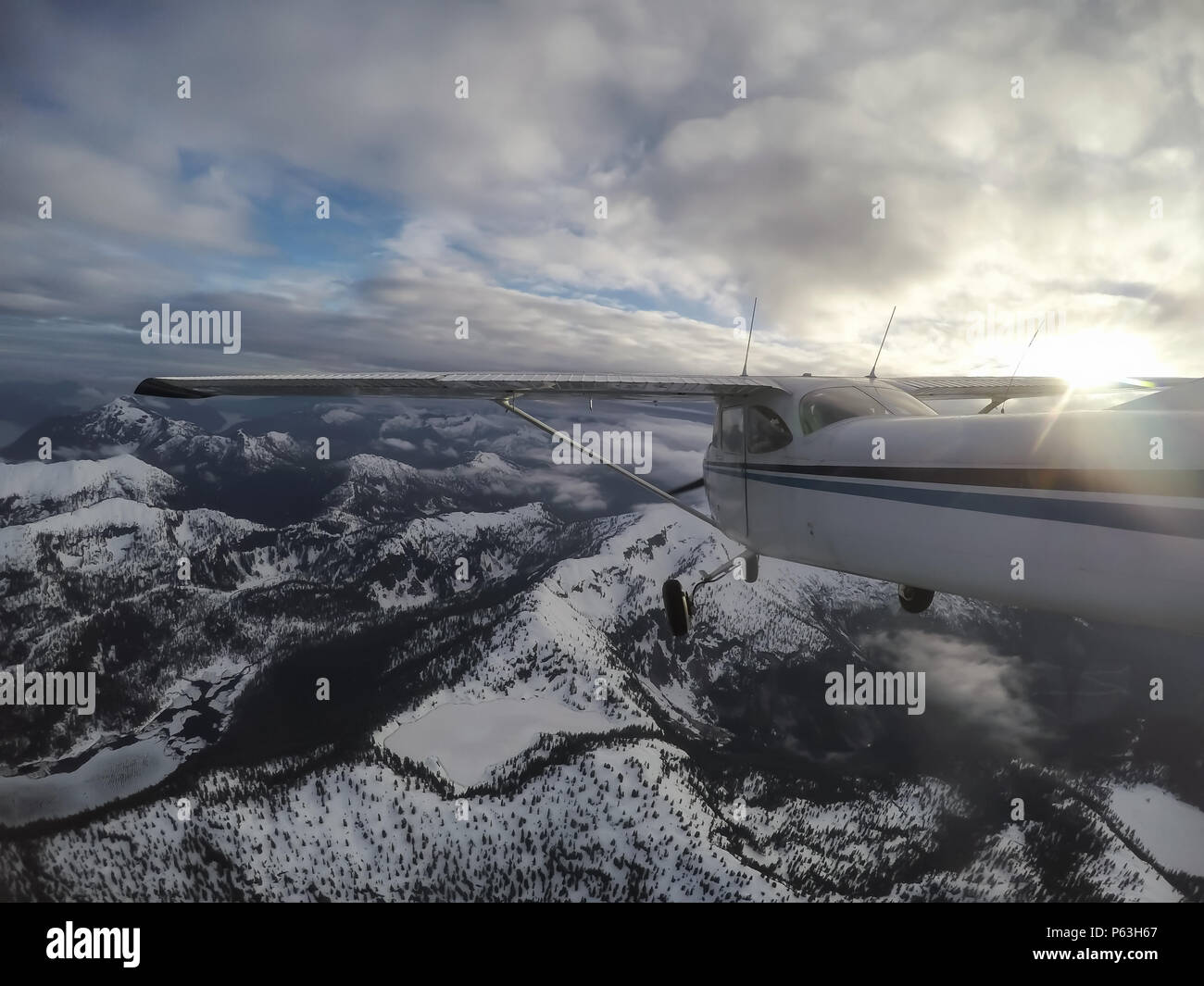 Airplane flying over the beautiful Canadian Mountain Landscape during a ...
