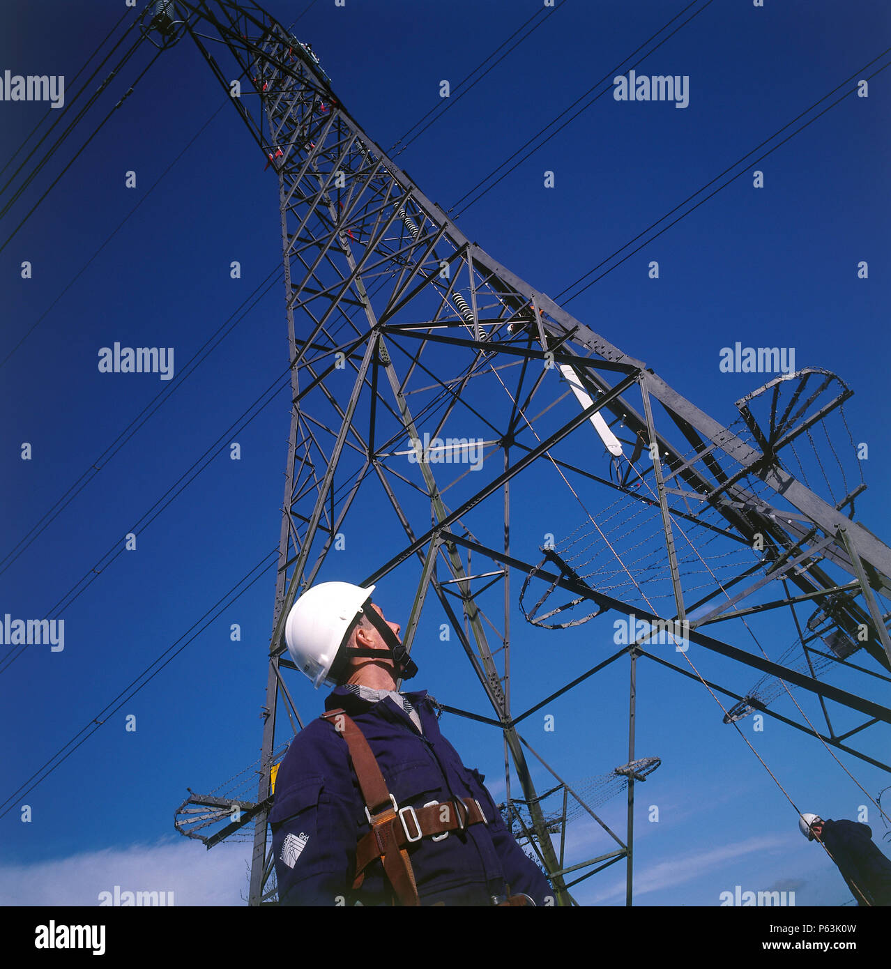 Worker in safety equipment ready to scale electricity pylon Stock Photo ...