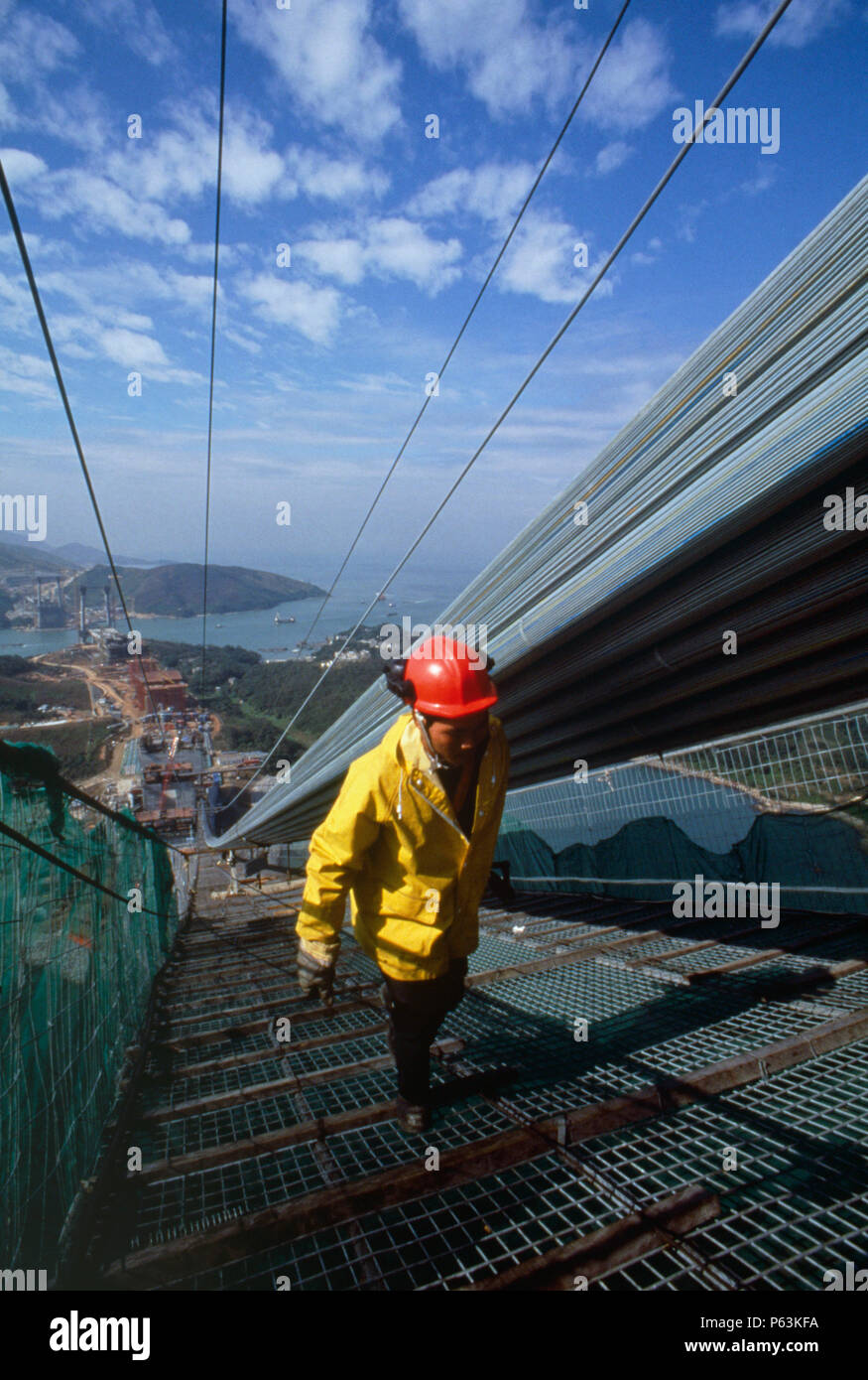 Worker climbs the suspended walkway beneath the cable being spun for ...