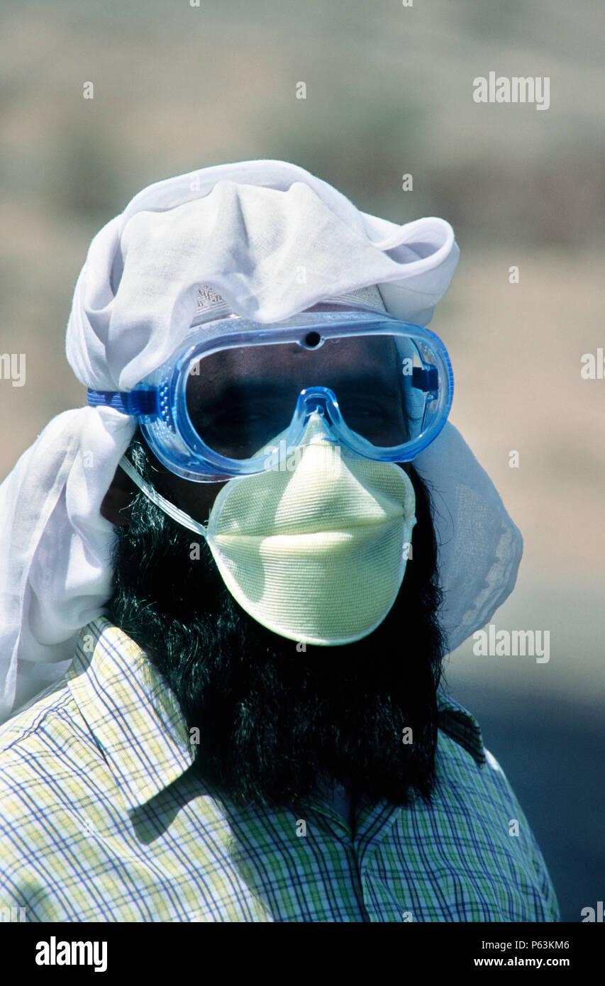 Asphalt worker with mask and protector goggles in the 48 degree heat ...