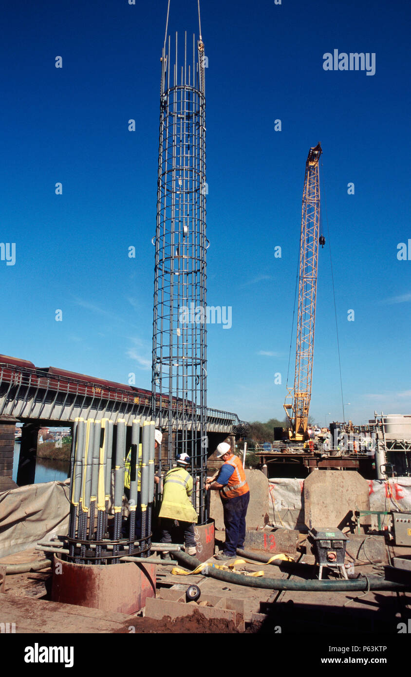 Lowering a reinforcement cage into a bored pile on a bridge foundation ...