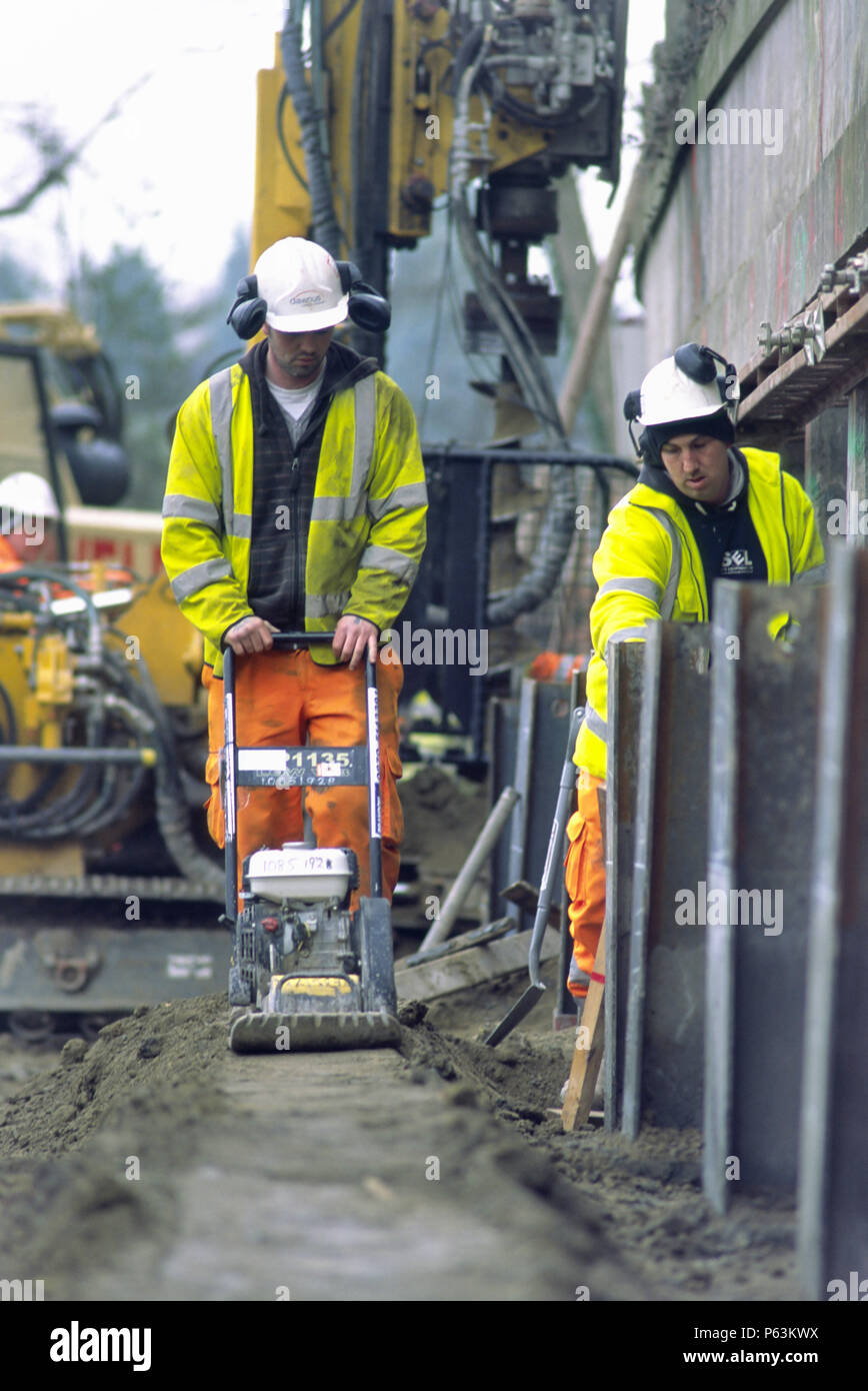 Small hand operated compactor unit being used to finish a lean concrete ...