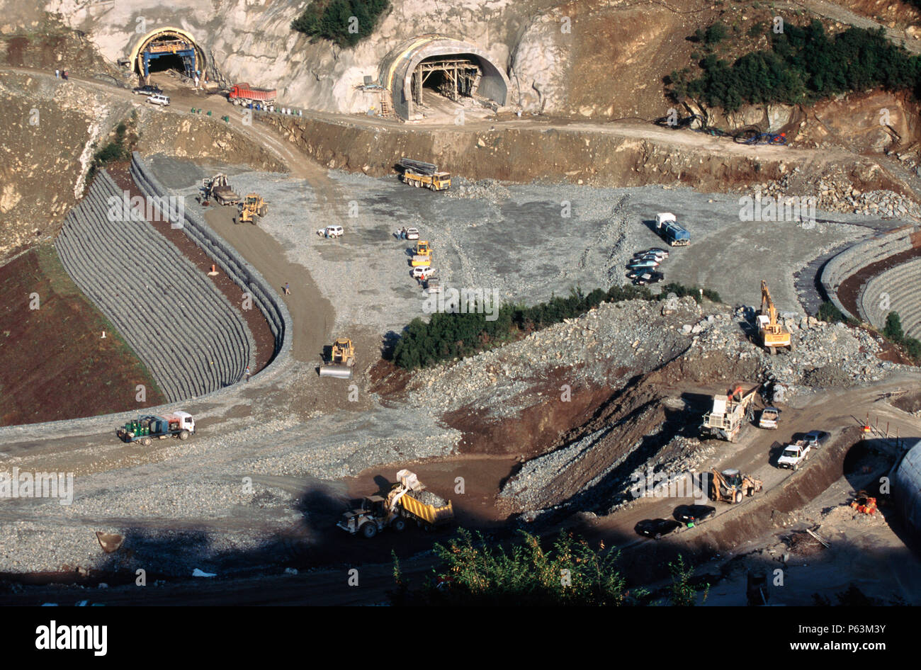 Scrapers and bulldozers level crushed rock fill for a gabion faced ...