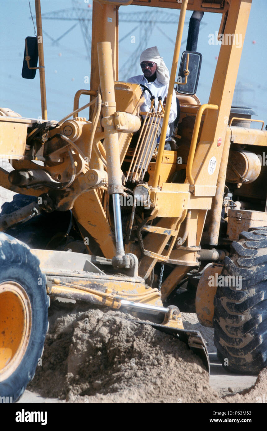 A grader levels the road base for later asphalting on the Dubai back ...