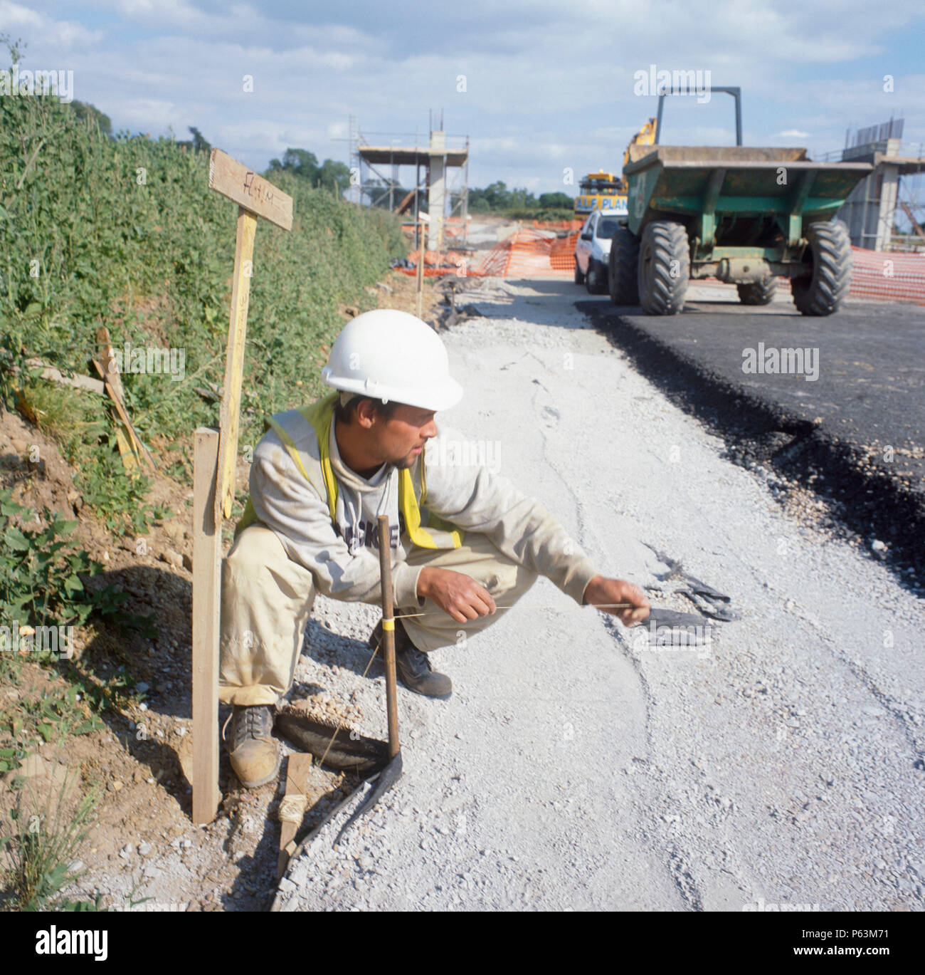 Adjusting a leveling line for road asphalting on a bypass project near ...