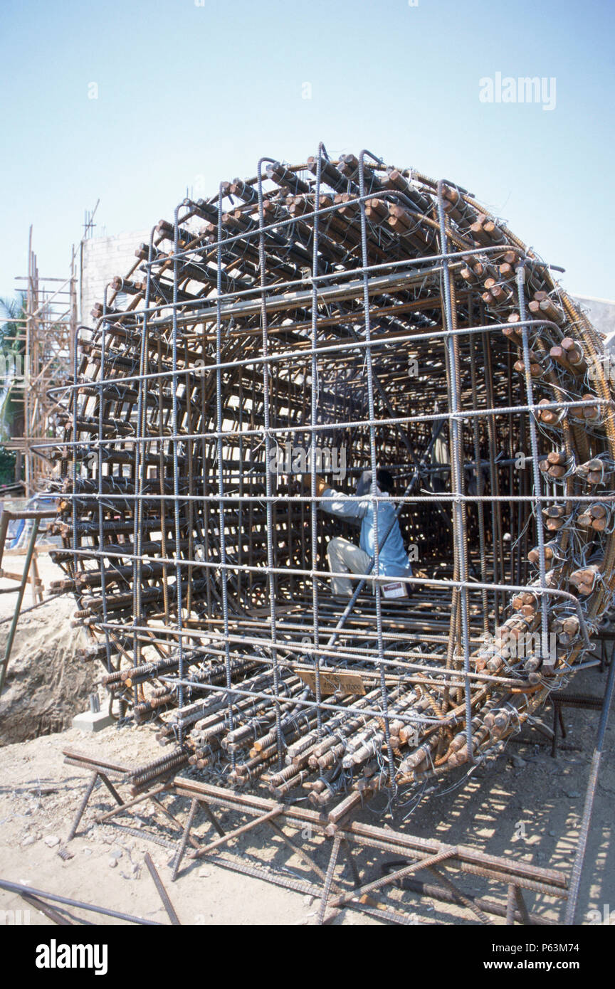Worker fixes steel for the heavy reinforcement cage for a seismically ...