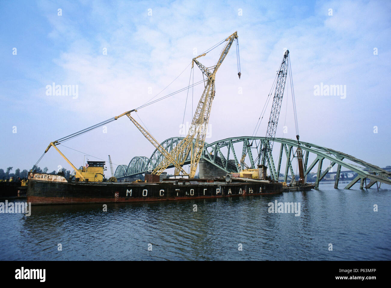 A floating crane is used to lift damaged sections of the rail bridge ...
