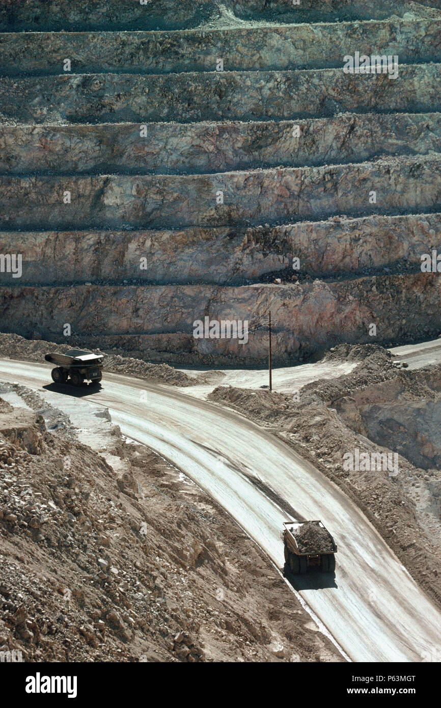 Haul trucks passing in a giant open cast pit goldmine in Nevada USA ...