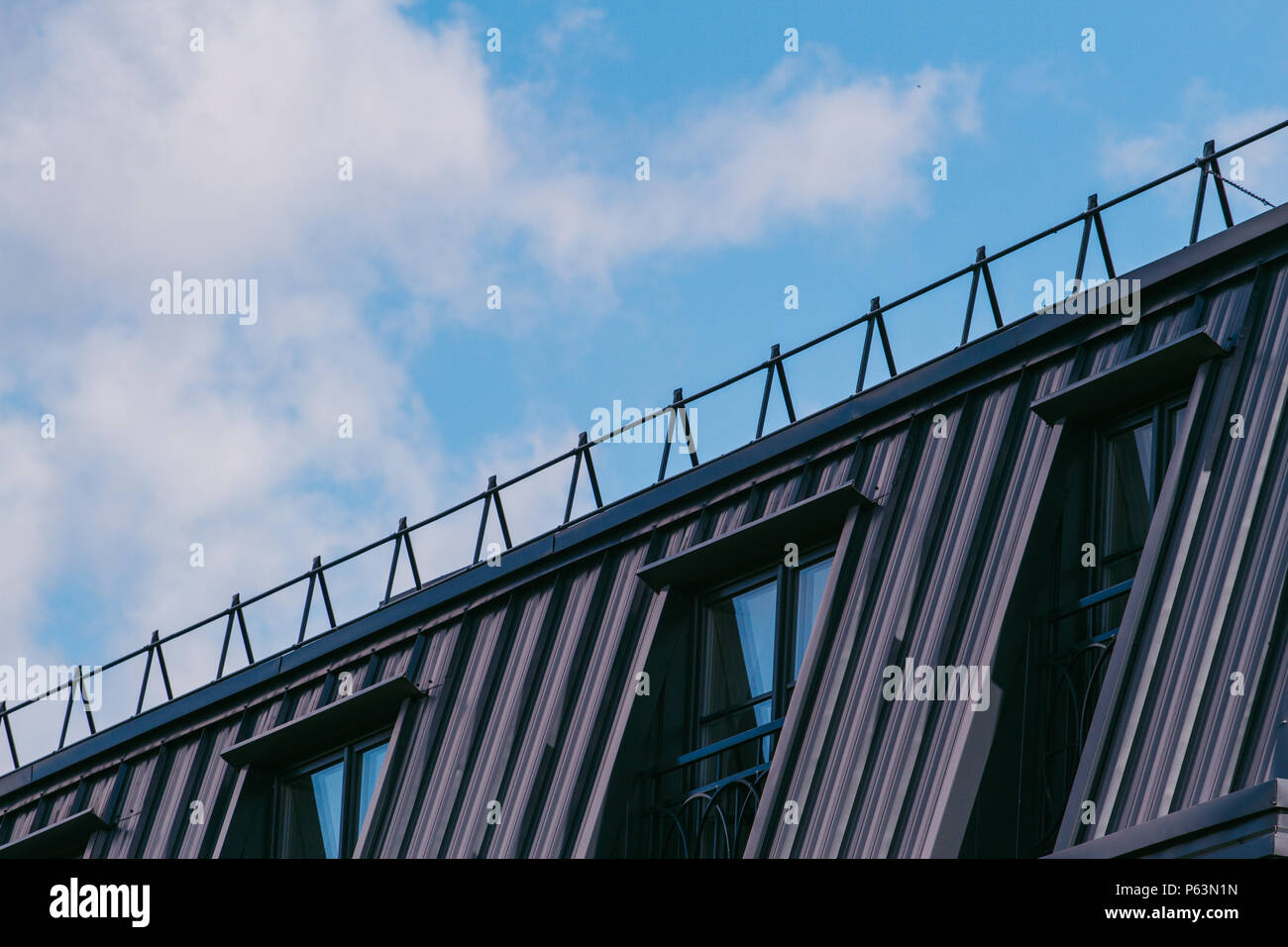 Modern house with a metal roof and windows against blue sky Stock Photo ...