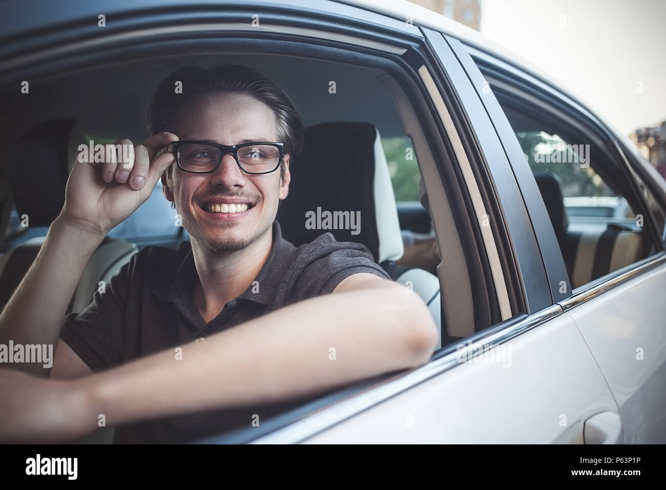 Enjoy the drive. Image of young handsome guy sitting in car Stock Photo ...