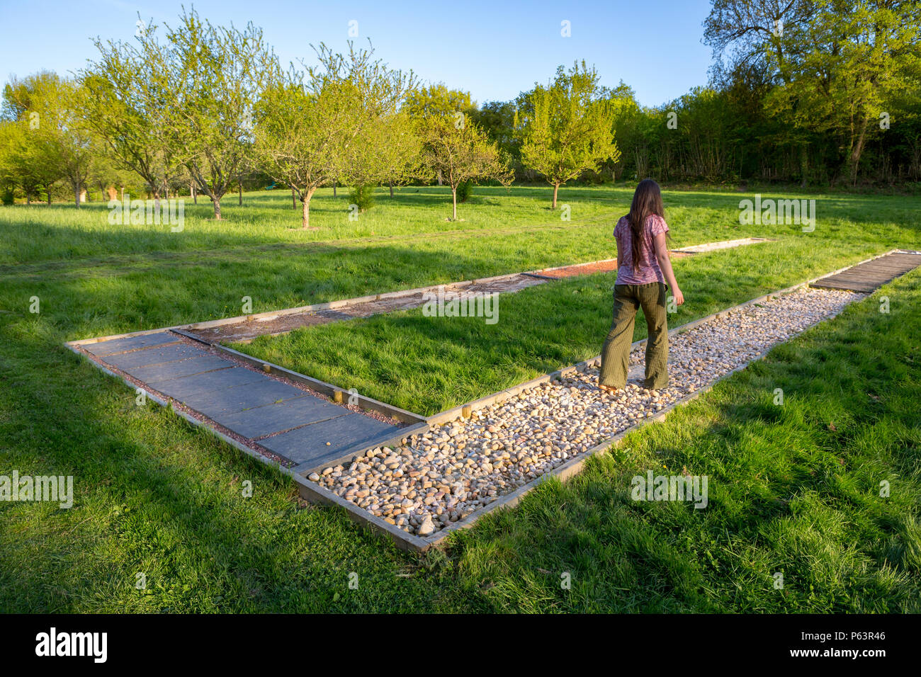 Woman walking on a barefoot track or trail on the afternoon sunlight ...