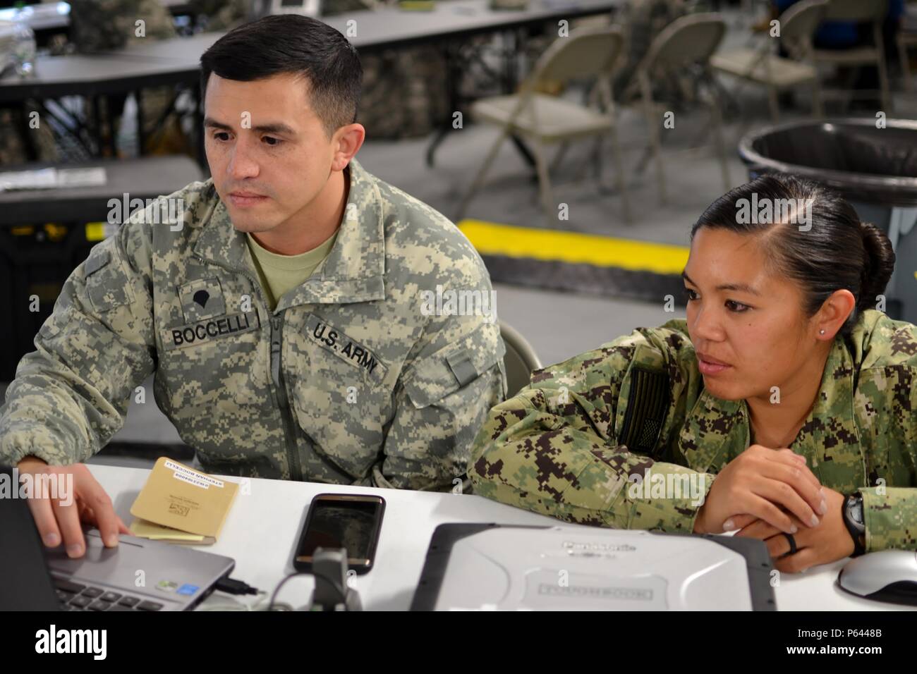 A Soldier and member of the U.S. Navy work on communication processes ...