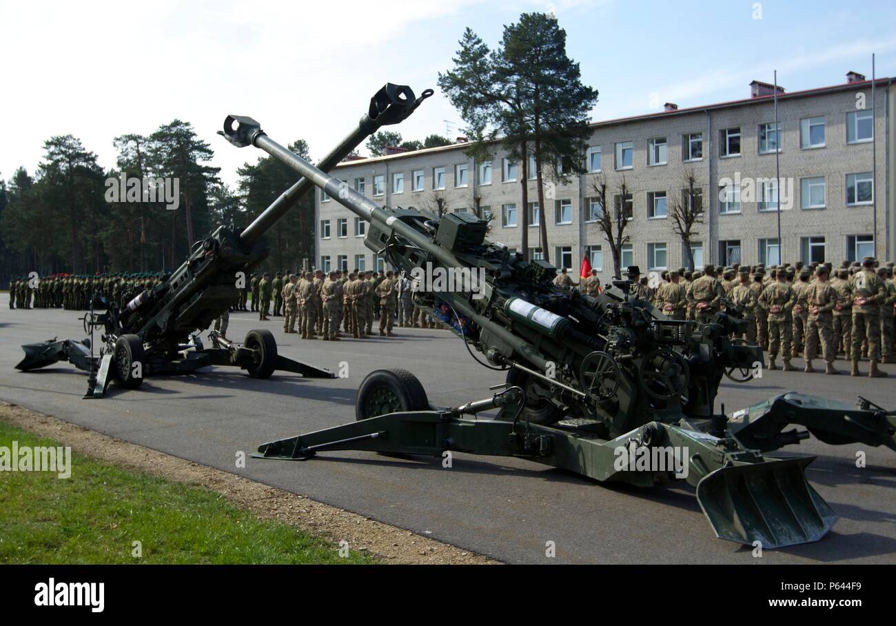 Two M777 Howitzers sit behind the formation of soldiers from six North ...