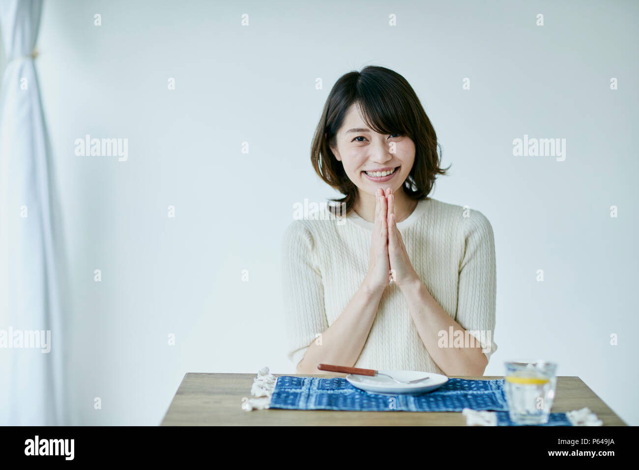 Young Japanese sitting at dining table Stock Photo - Alamy