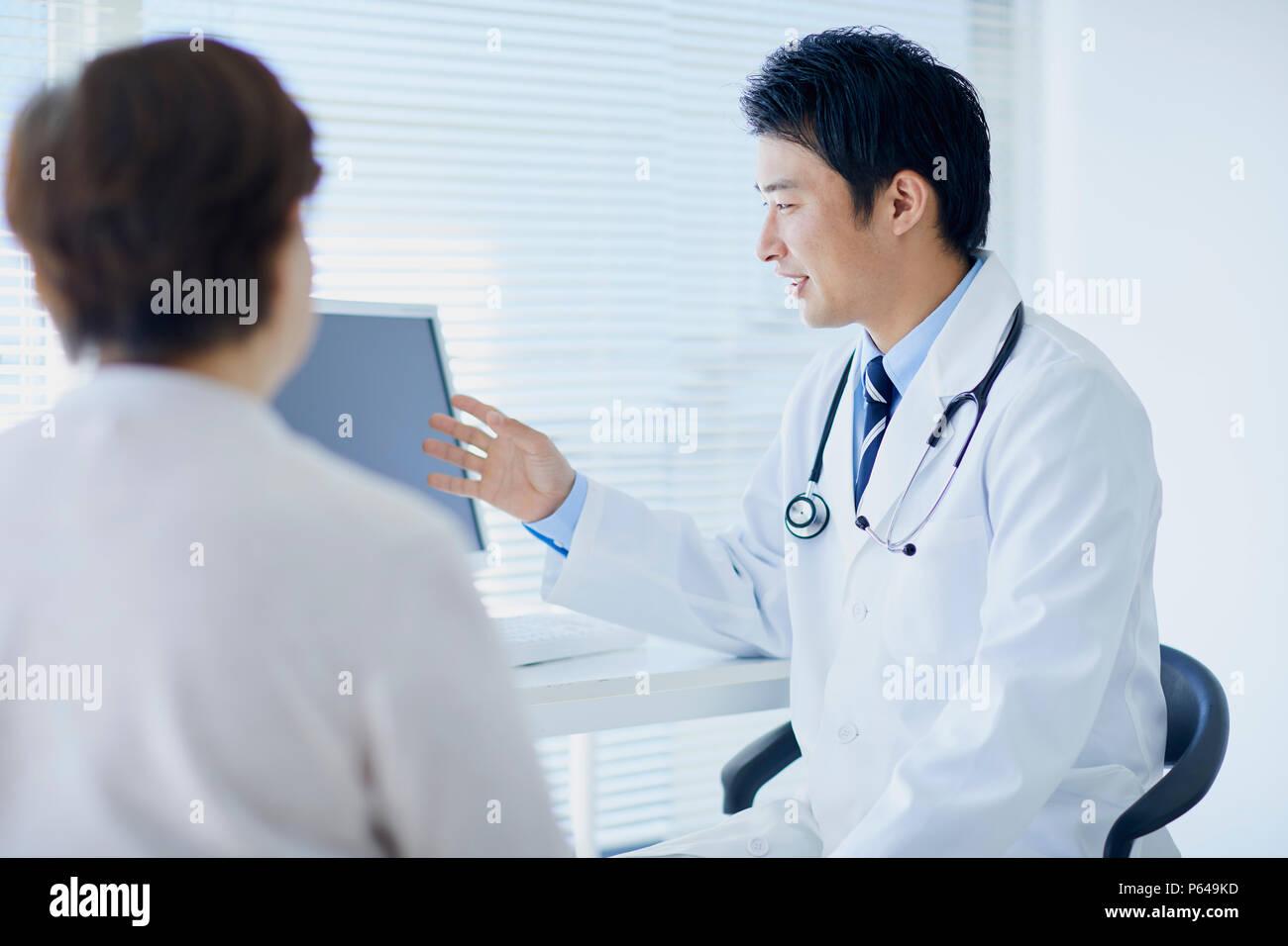 Japanese doctor with a patient in his studio Stock Photo - Alamy