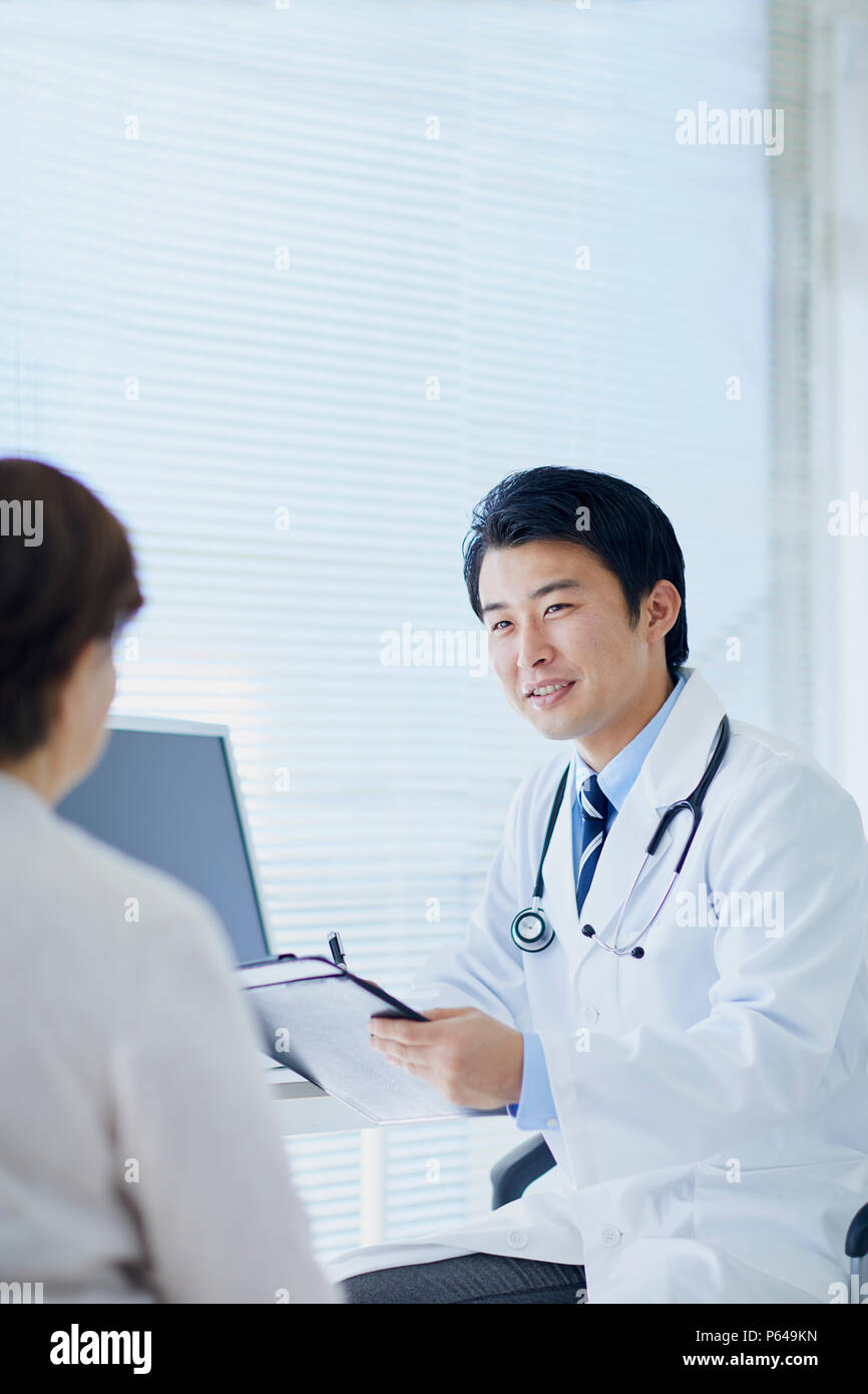 Japanese doctor with a patient in his studio Stock Photo - Alamy