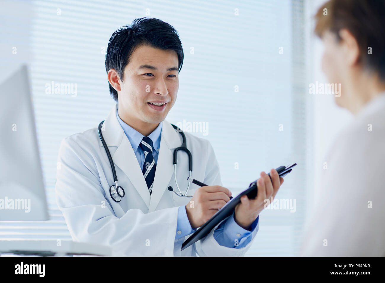 Japanese doctor with a patient in his studio Stock Photo - Alamy