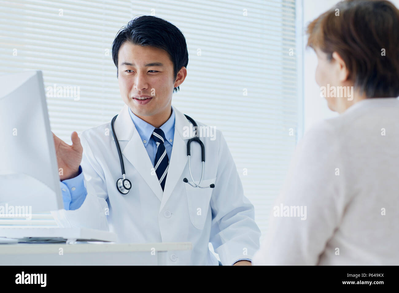 Japanese doctor with a patient in his studio Stock Photo - Alamy