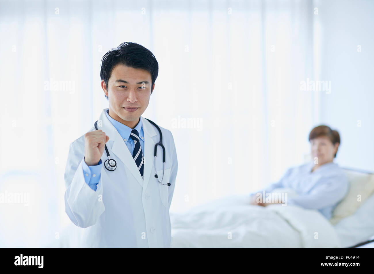 Japanese doctor with a patient in bed Stock Photo - Alamy
