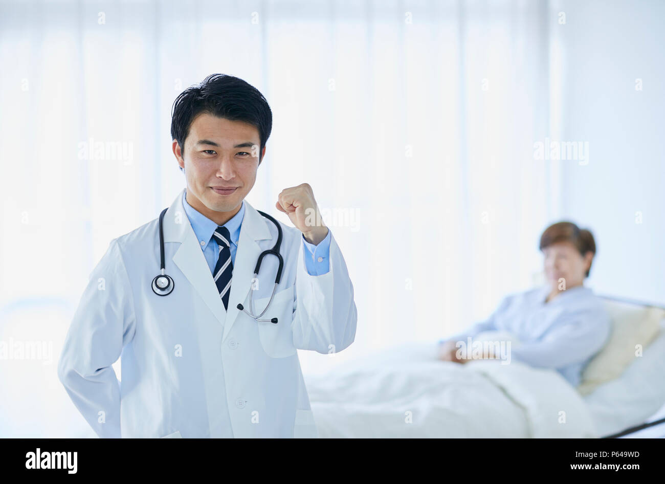 Japanese doctor with a patient in bed Stock Photo - Alamy