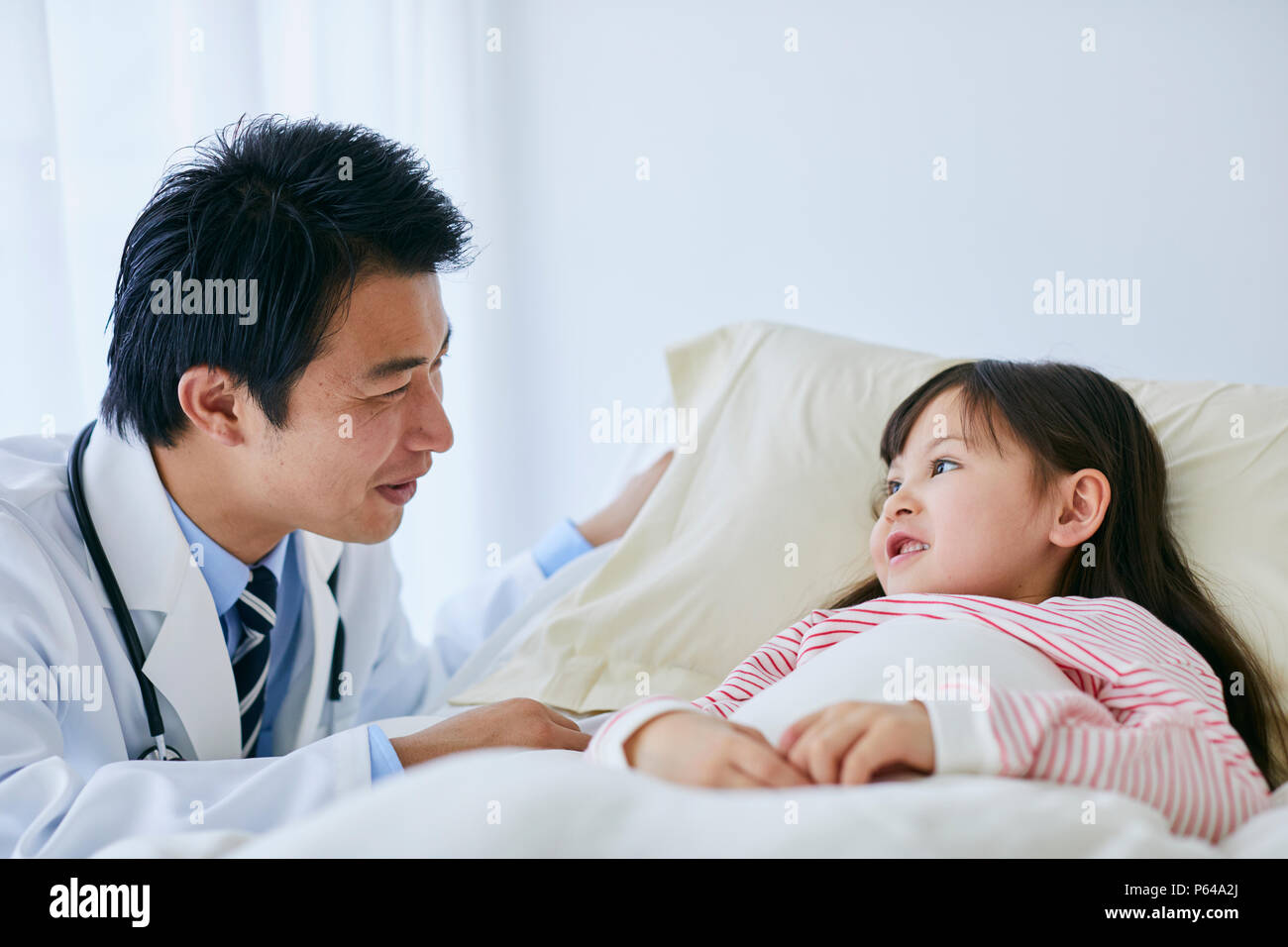 Japanese doctor with a patient in bed Stock Photo - Alamy