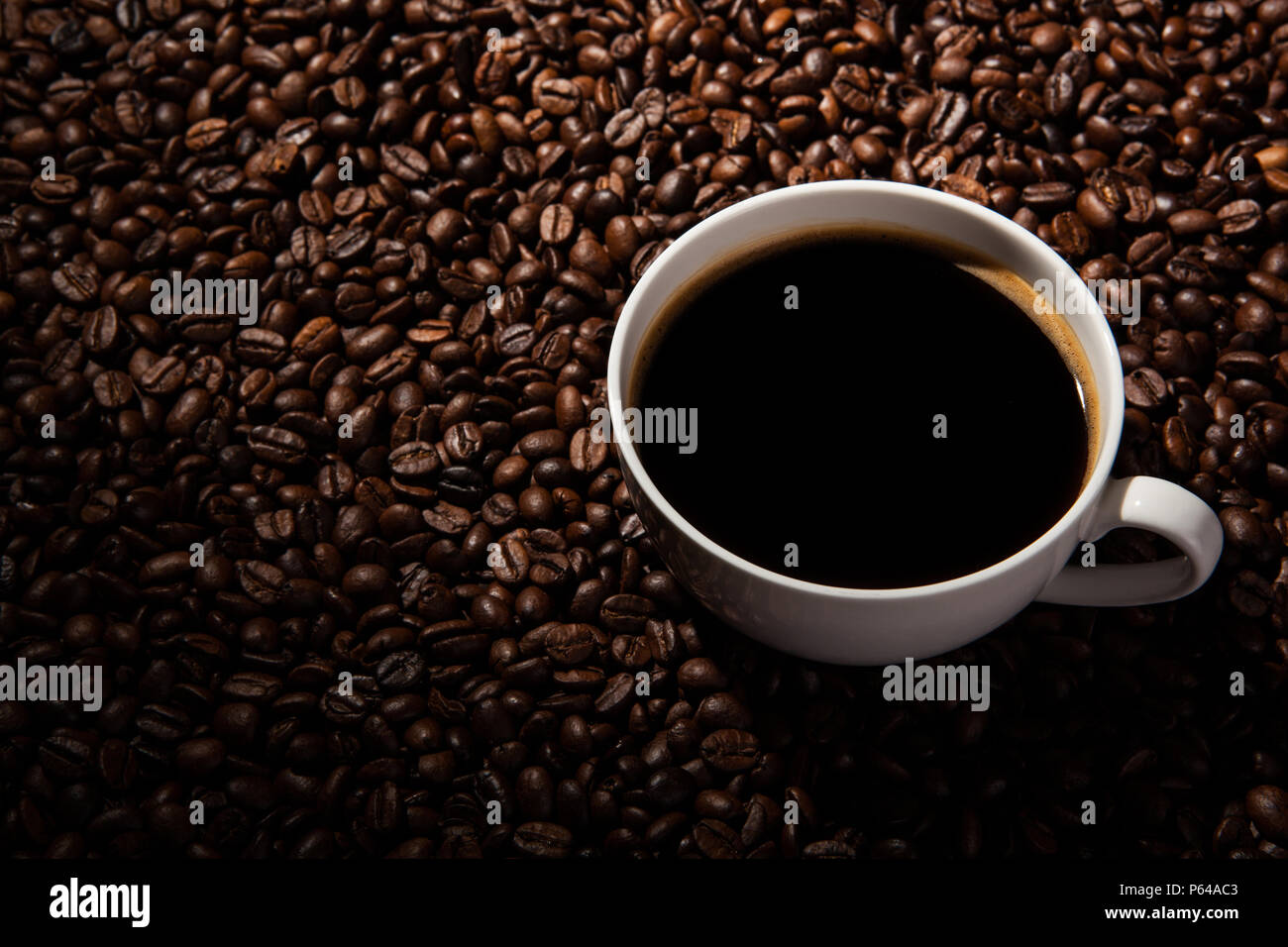 Still-life with a cup of black coffee and roasted coffee beans close up ...