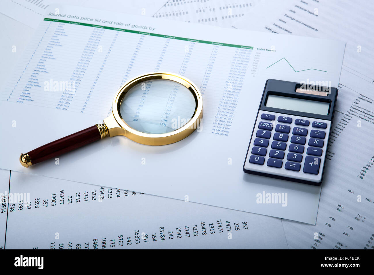 work with a magnifying glass, a calculator and papers Stock Photo - Alamy